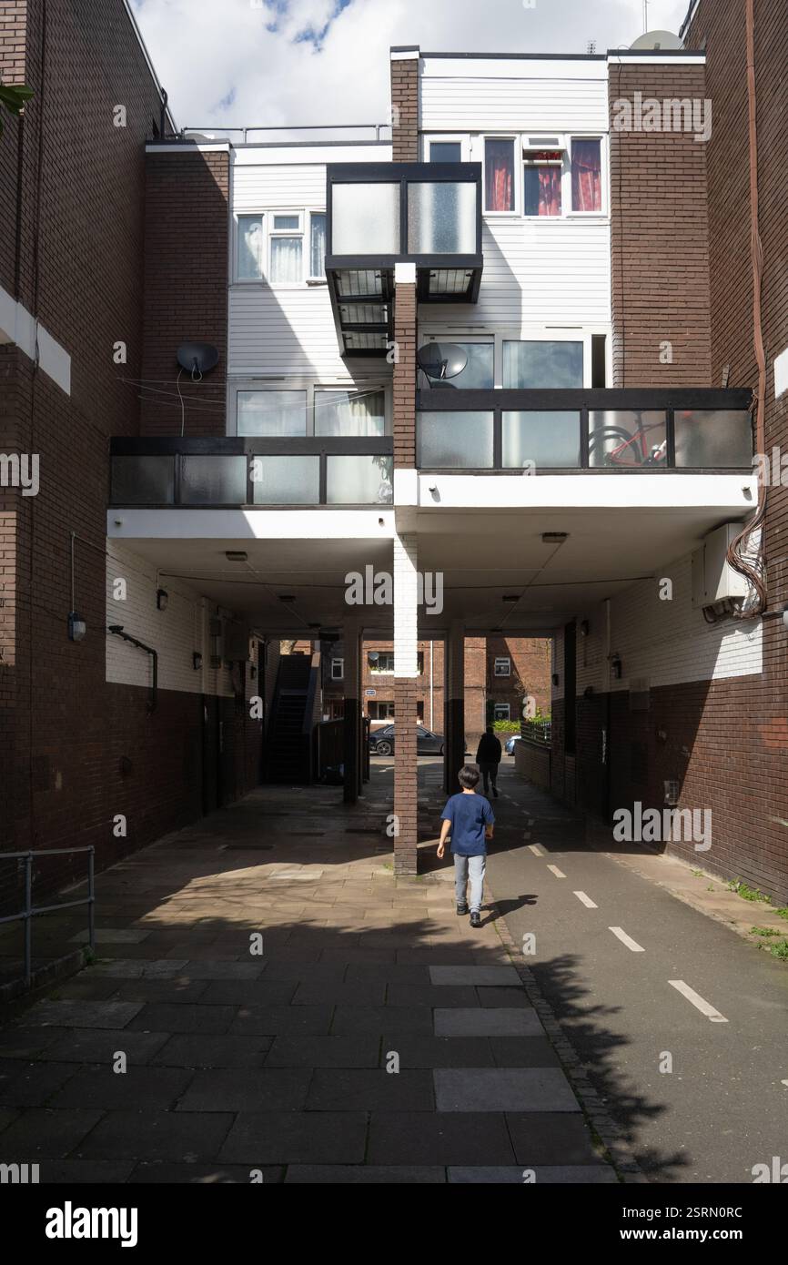 A child walks through a passageway between multi-story buildings in ...