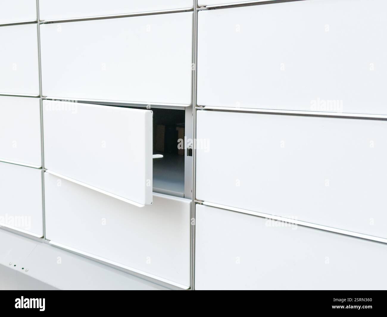 Open locker in a modern white parcel locker system for delivery and ...