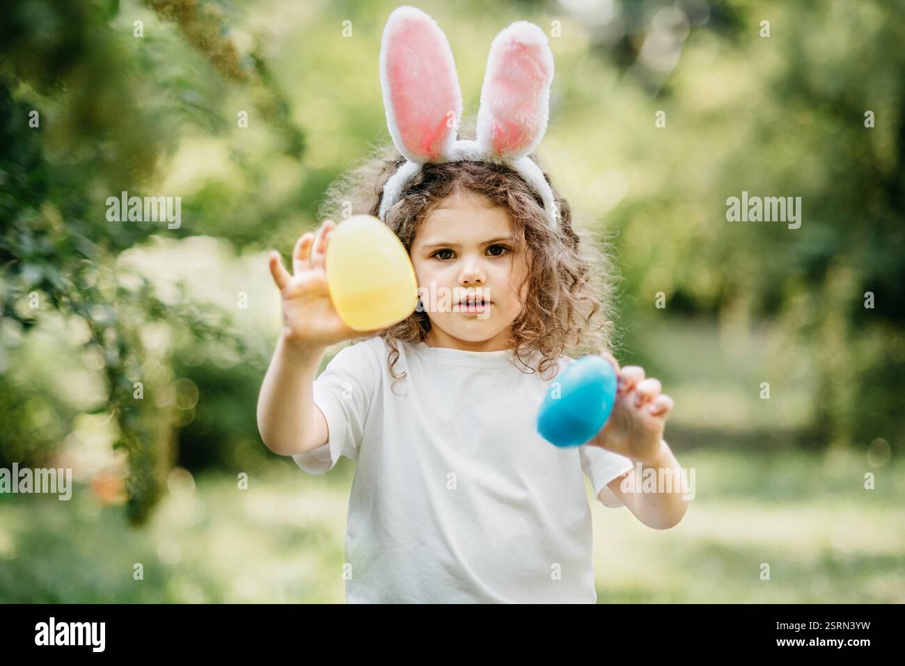 Easter egg hunt. Girl child Wearing Bunny Ears Running To Pick Up Egg ...