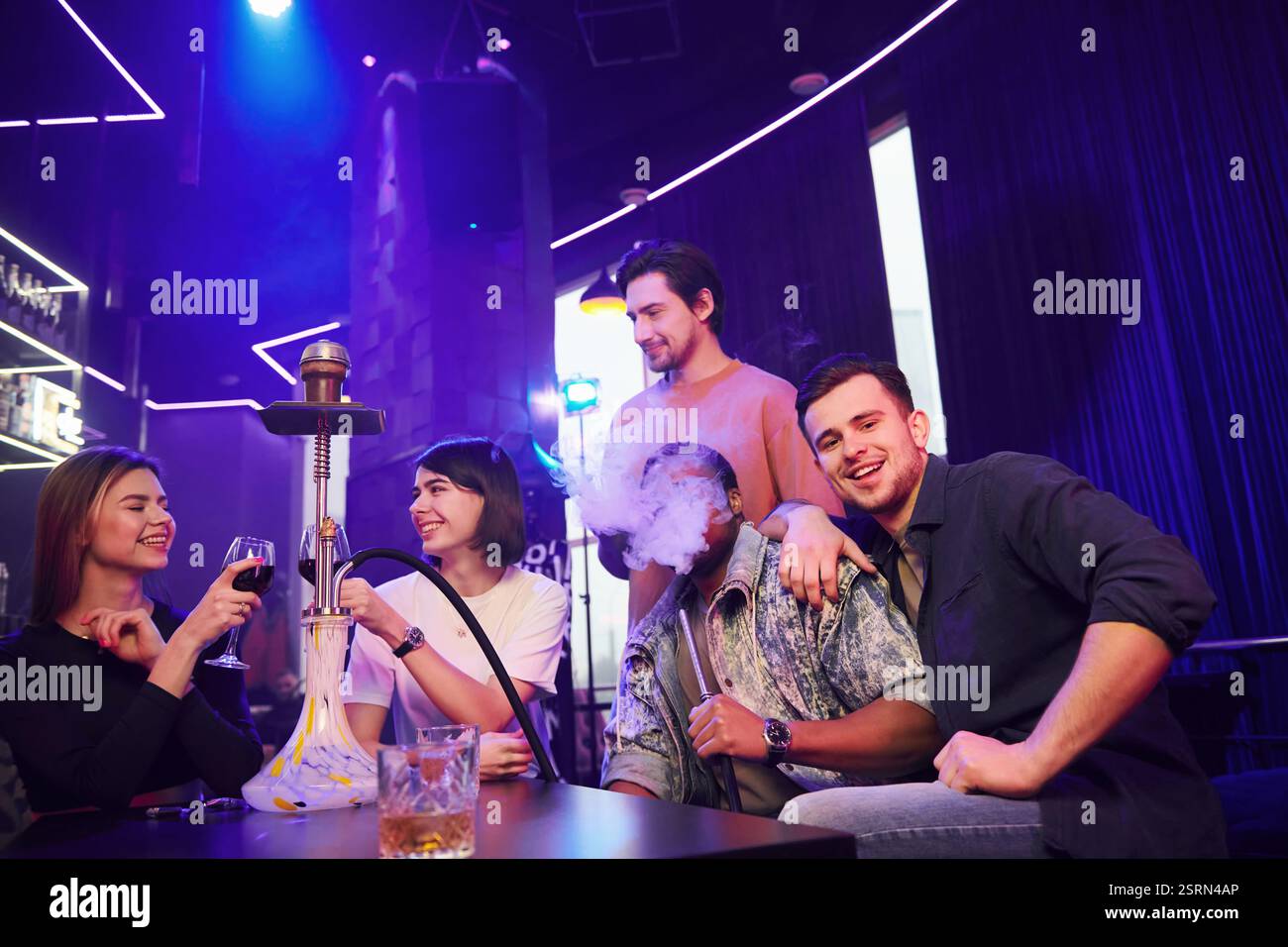 Smiling and partying. Group of friends having fun in the night club ...