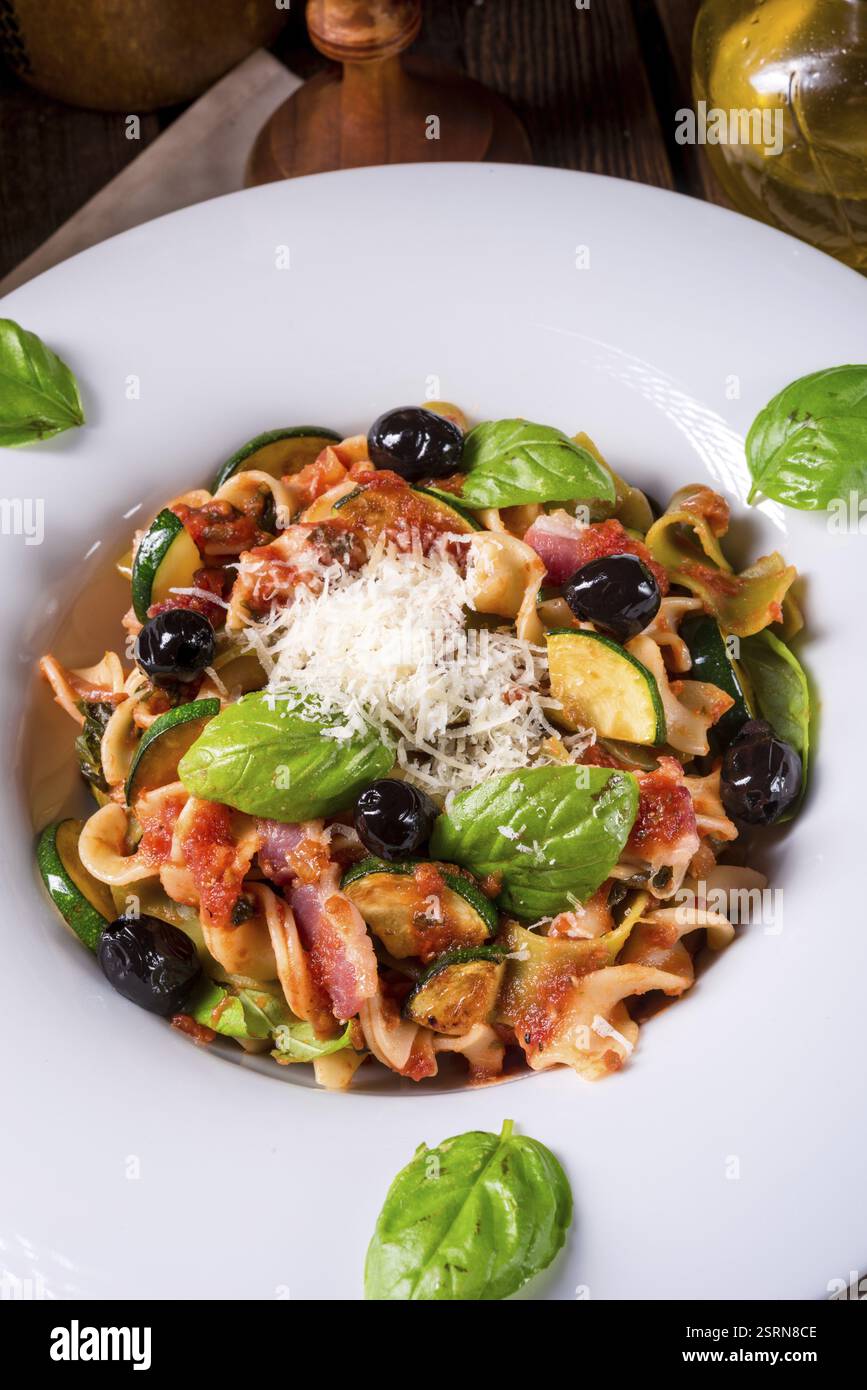 Ribbon Pasta with courgette and olives in tomato sauce Stock Photo - Alamy