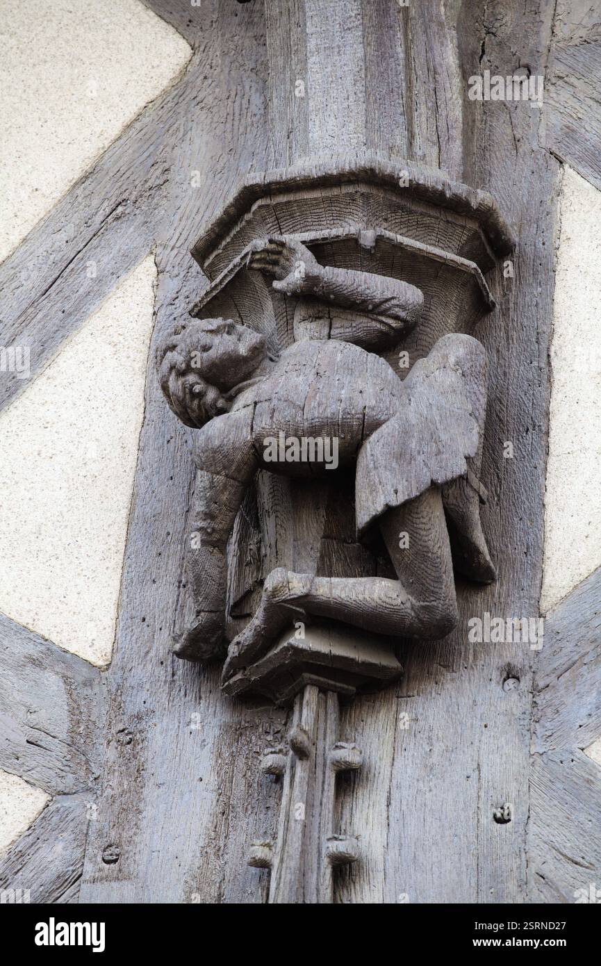 A unique wooden sculpture of a figure climbing a pillar adorns a ...
