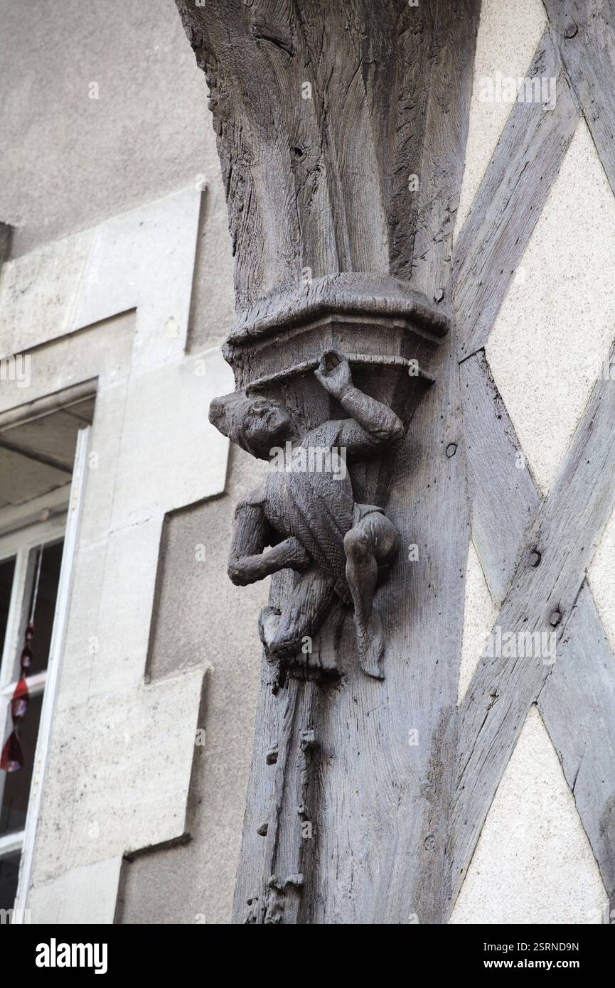 A unique wooden sculpture of a figure climbing a pillar adorns a ...