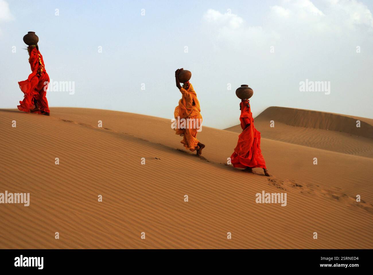 Rajasthani women with earthen pitchers on head climbing sand dune of ...
