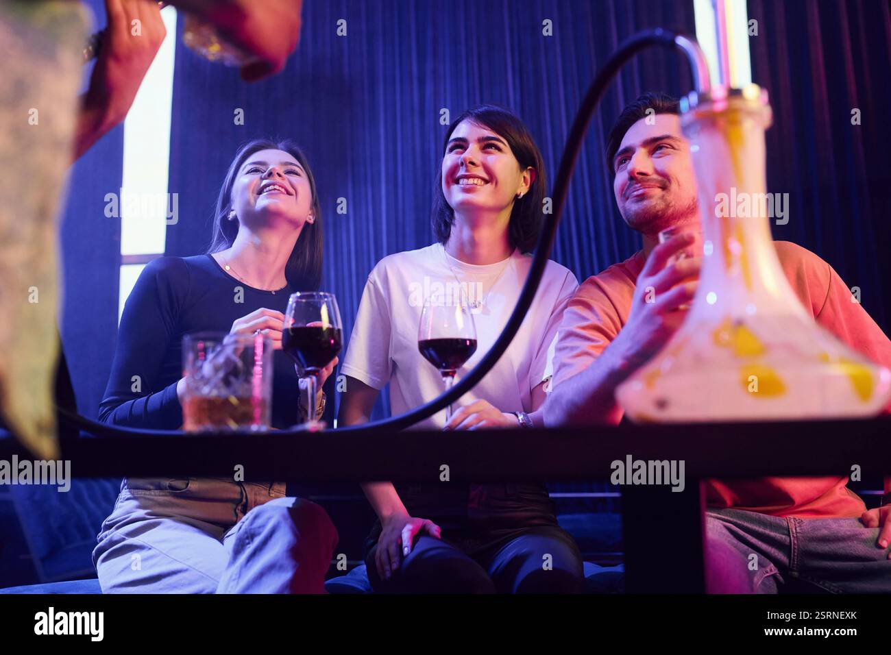 Talking with each other. Group of friends having fun in the night club ...