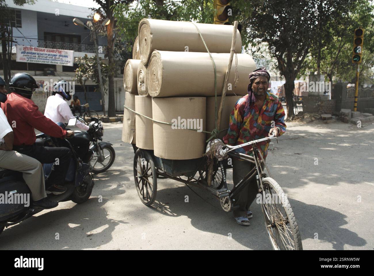 Cycle rickshaw carrying huge load of paper rolls on streets near Delhi ...