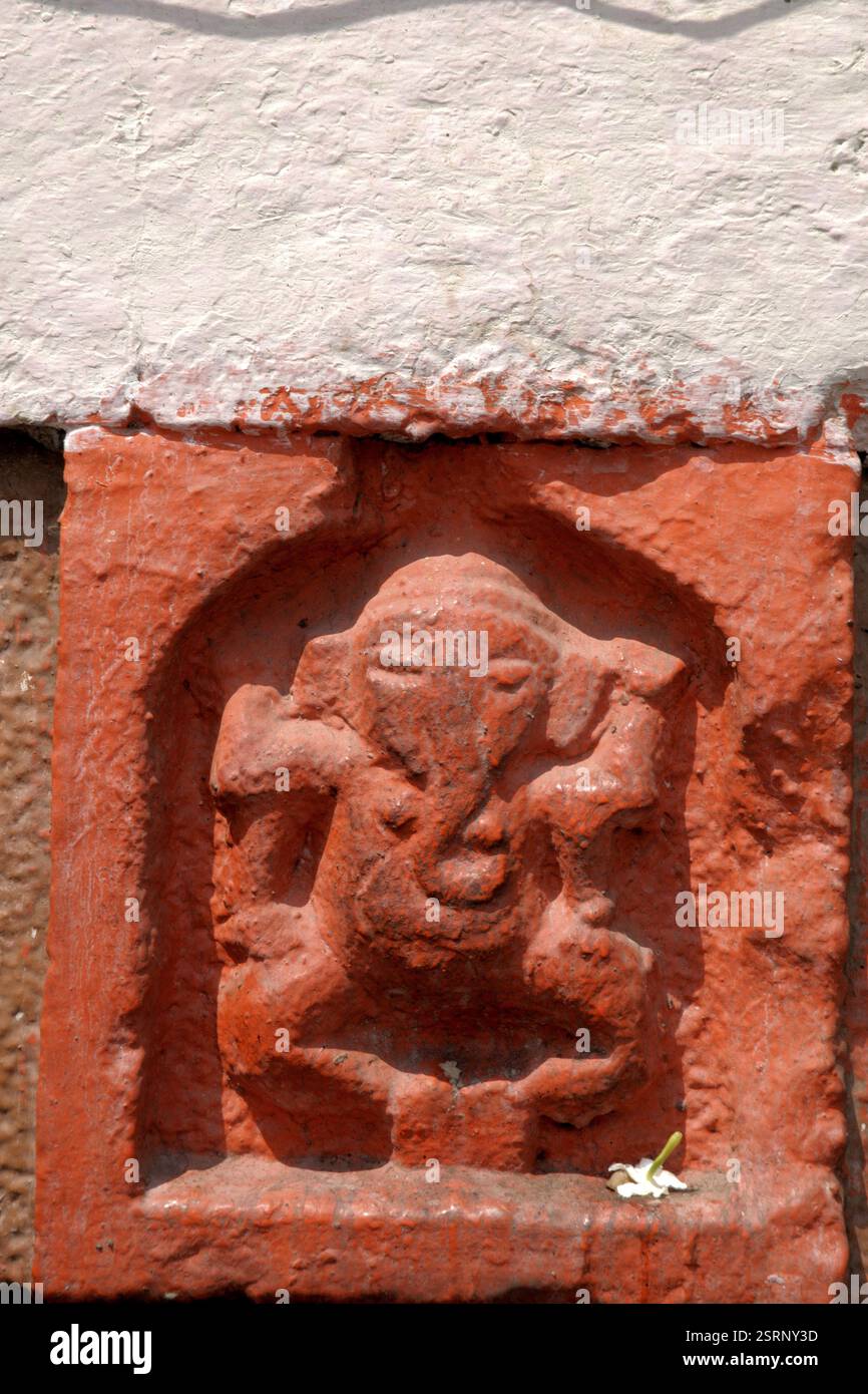 Red idol of lord Ganesh sculptured on wall, Khidrapur, Solapur ...
