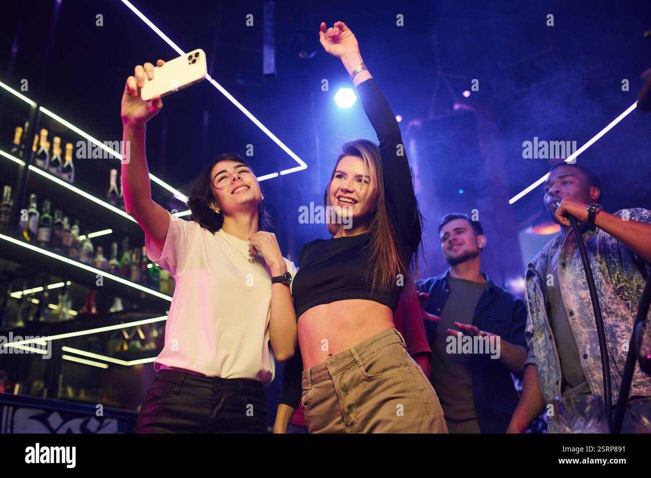 Two women making selfie. Group of friends having fun in the night club ...