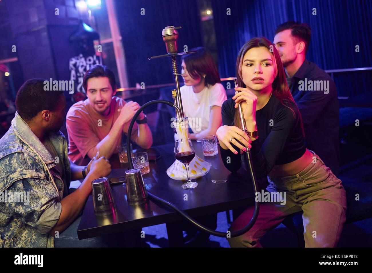 Artificial blue lighting. Group of friends having fun in the night club ...