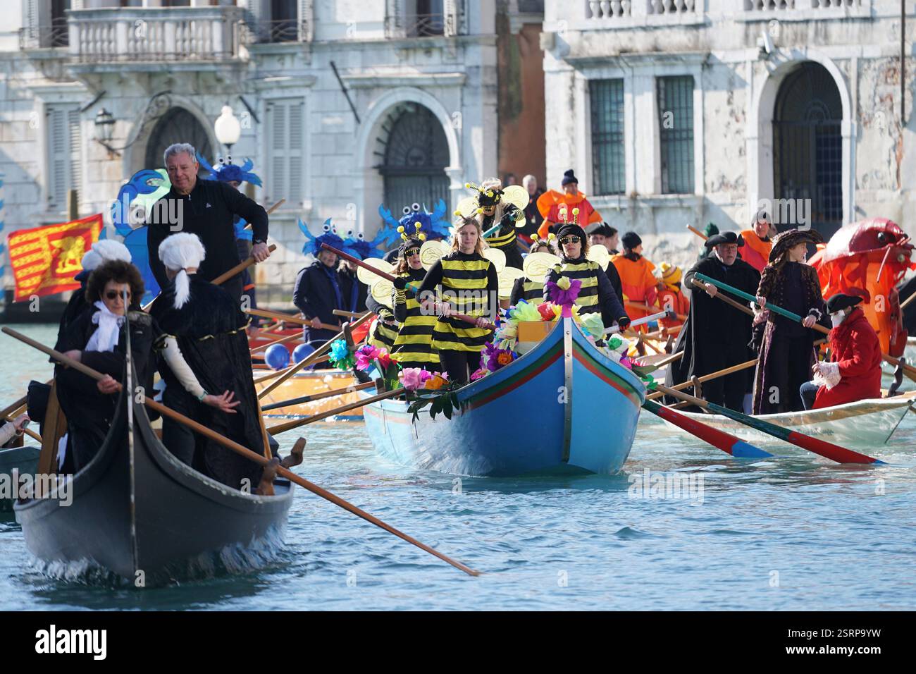 Rowers dressed in carnival costumes row traditional boats during the ...