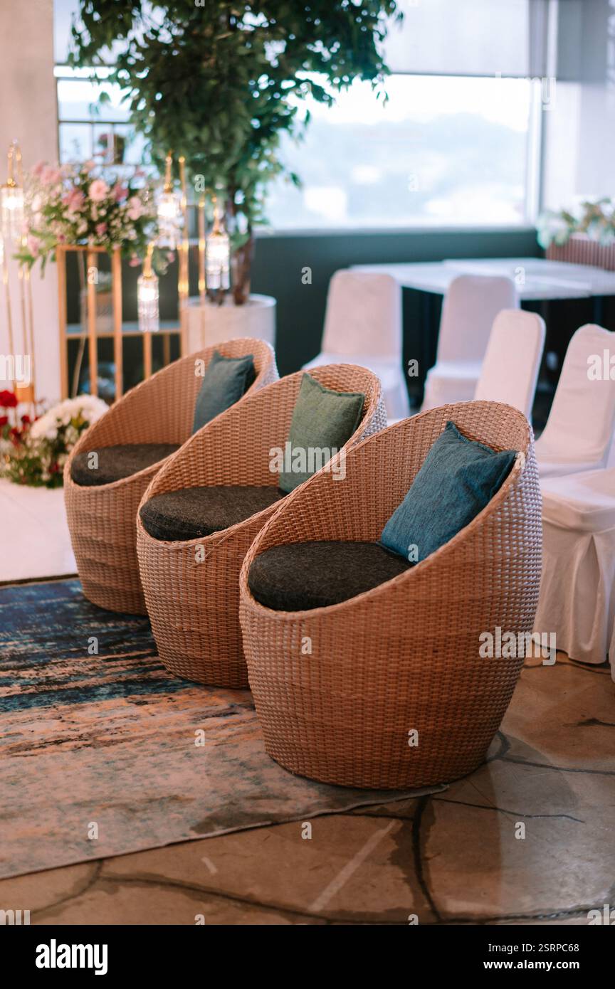 A stylish seating arrangement features woven chairs with soft cushions ...