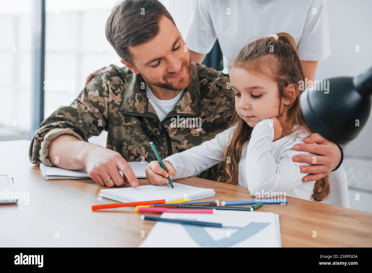 Sitting by the table. Soldier in uniform is at home with his wife and ...