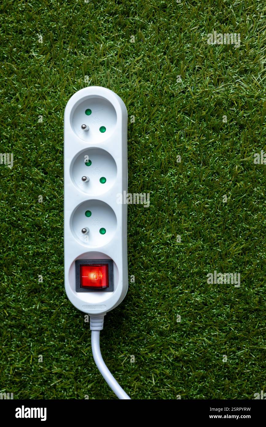 Power strip on the grass. Environmental concept. Green energy, modern ...