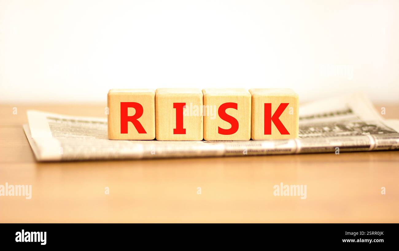 Risk symbol. Concept word Risk on beautiful wooden blocks on newspaper ...