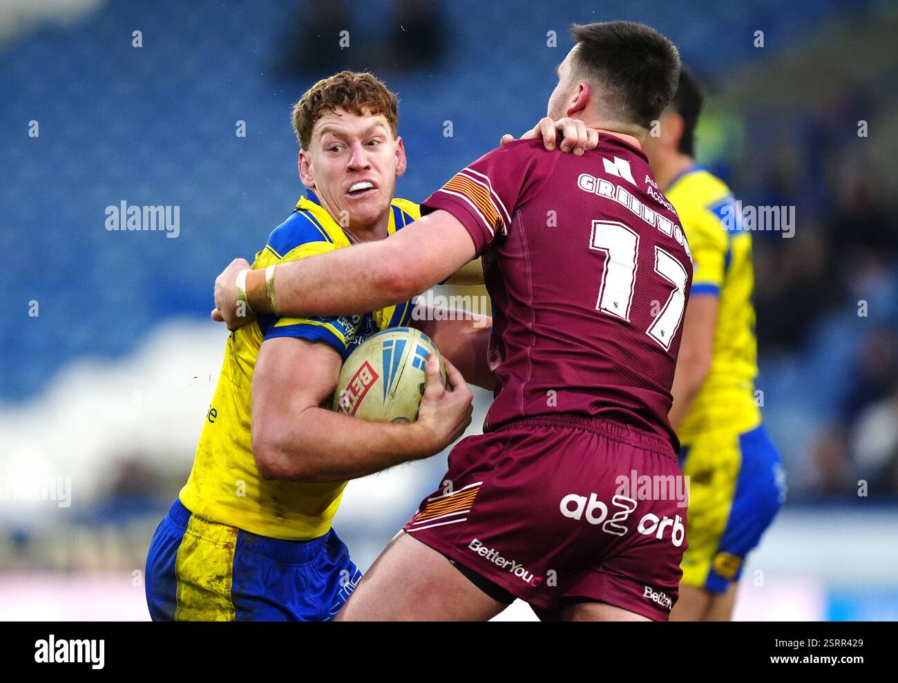 Warrington Wolves' Daniel Russell (left) tackled by Huddersfield Giants ...