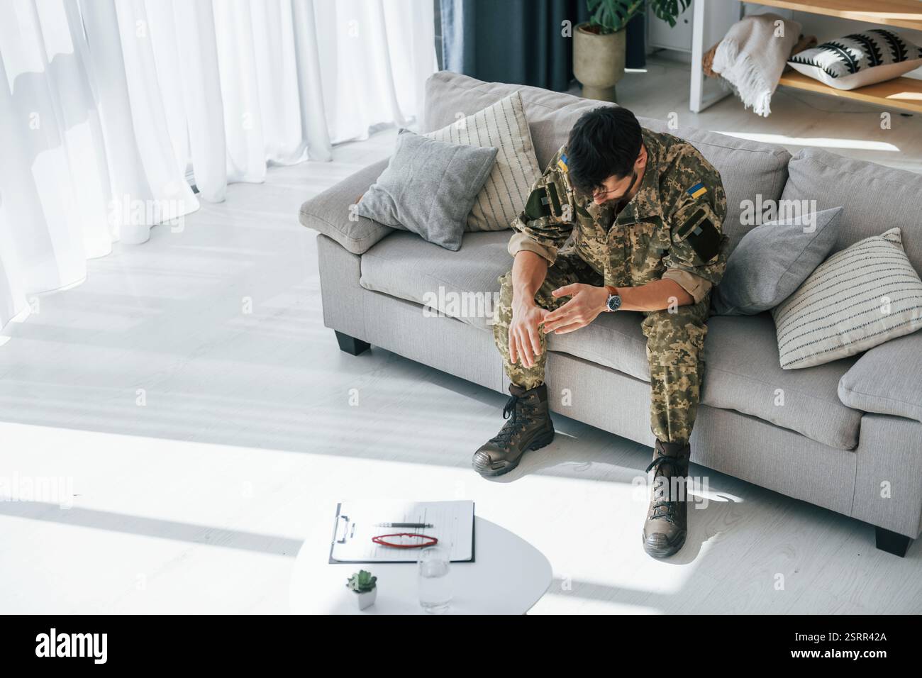 Bad mood. Post traumatic stress disorder. Soldier in uniform sitting ...