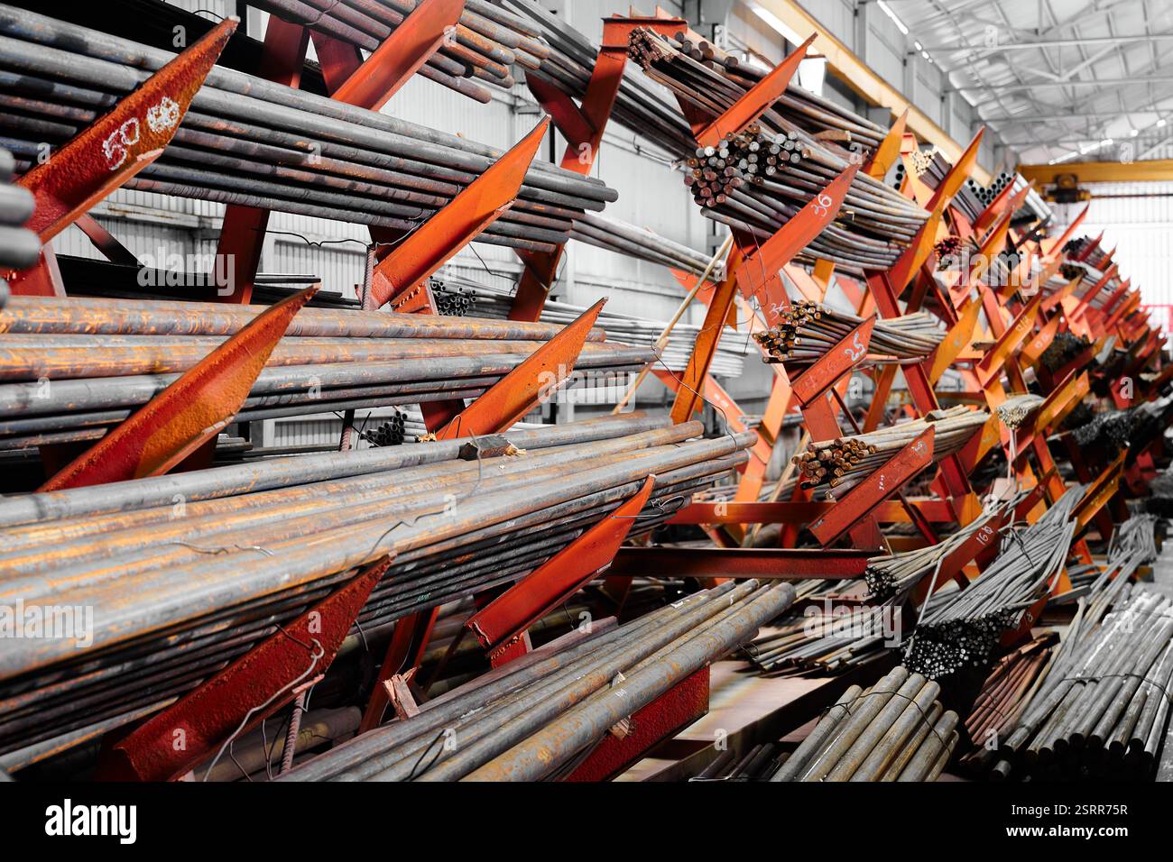 Thin metal rods stack on large rack in cold plant warehouse Stock Photo ...
