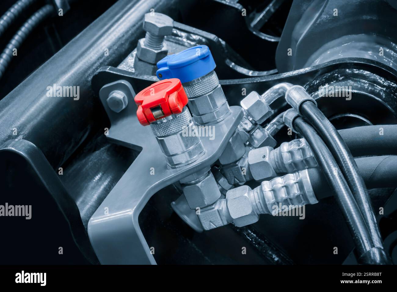 A close up of a car engine with a blue and red cap on a hose. The hose ...