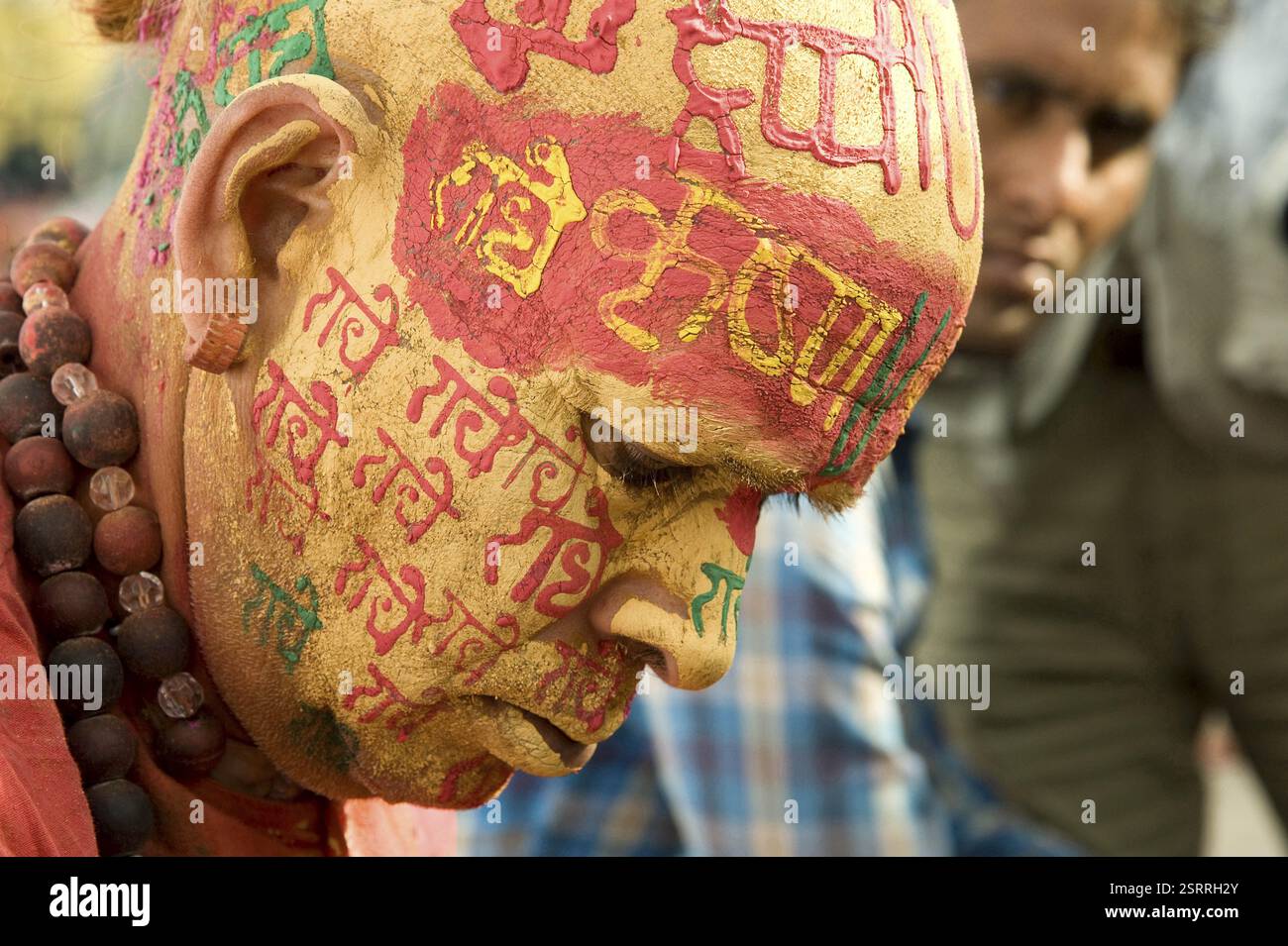 Priest writing radhe krishna on face by sandalwood paste, uttar pradesh ...