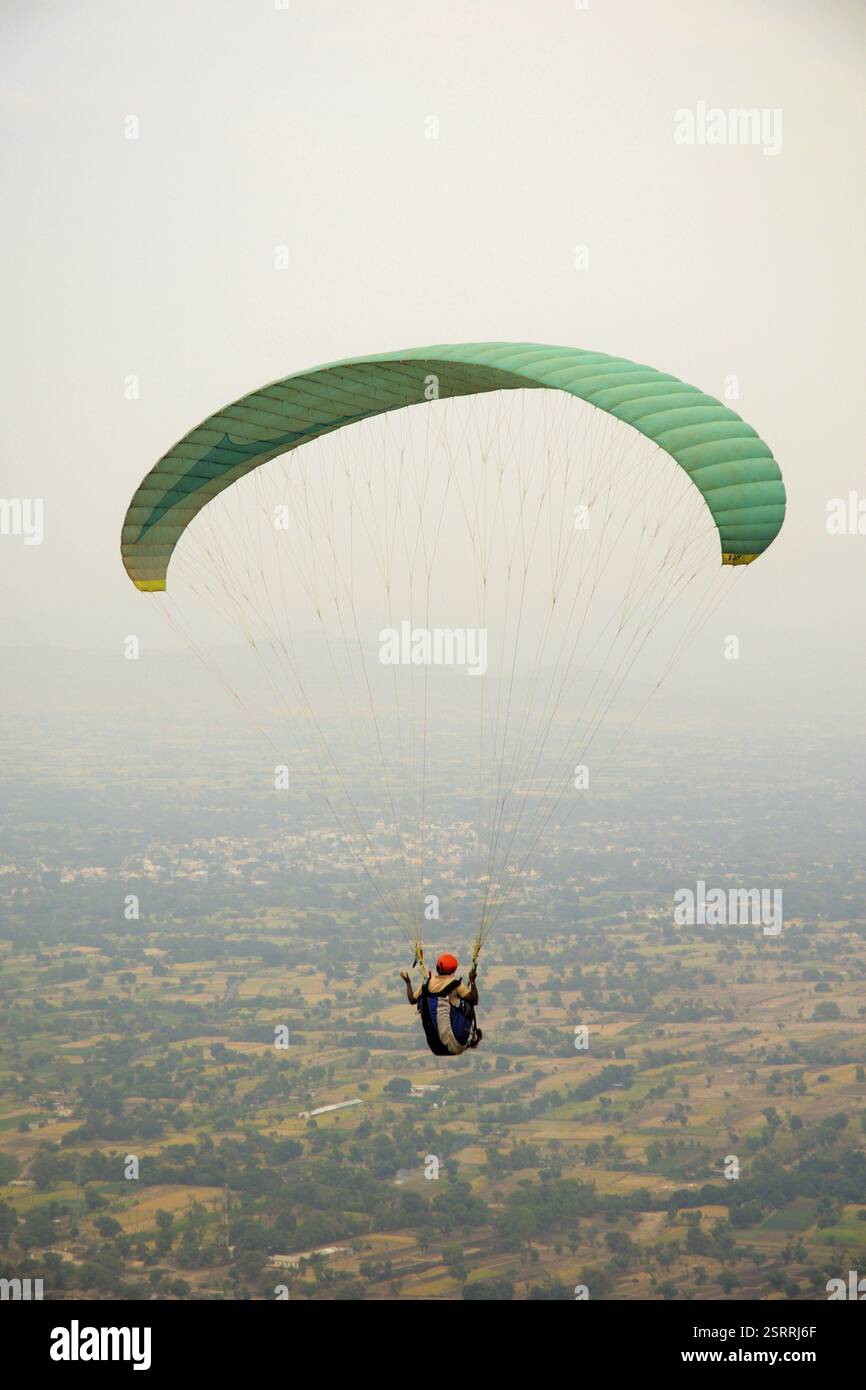 Paraglider with green parachute flying in air, Panchgani, Maharashtra ...