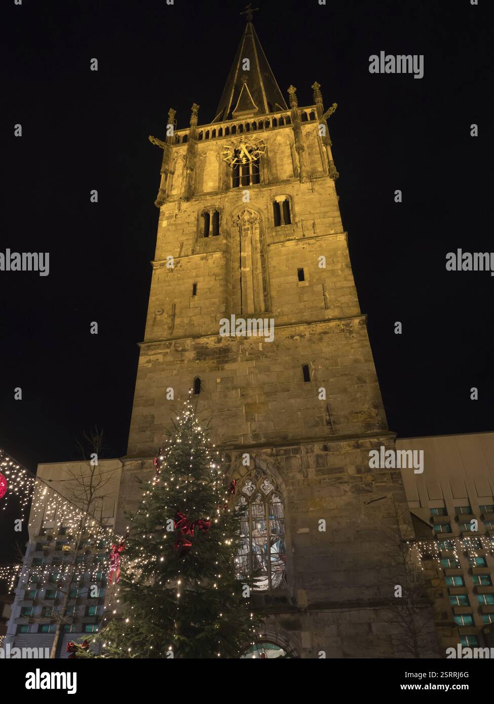 Illuminated church tower in gothic style at night with decorated ...