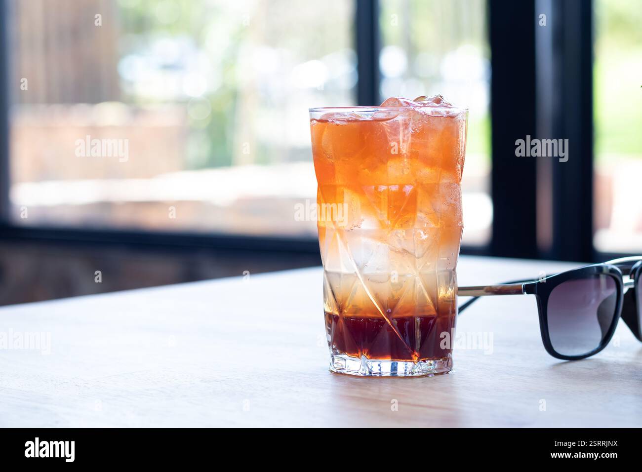 Refreshing iced tea with a decorative glass and sunglasses on a table ...
