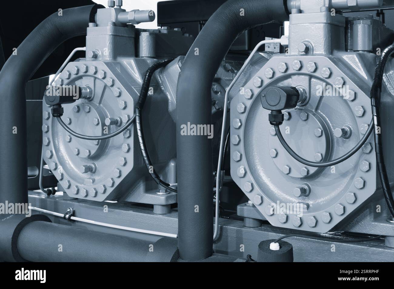 Two large gray and black industrial machines with many bolts and screws ...