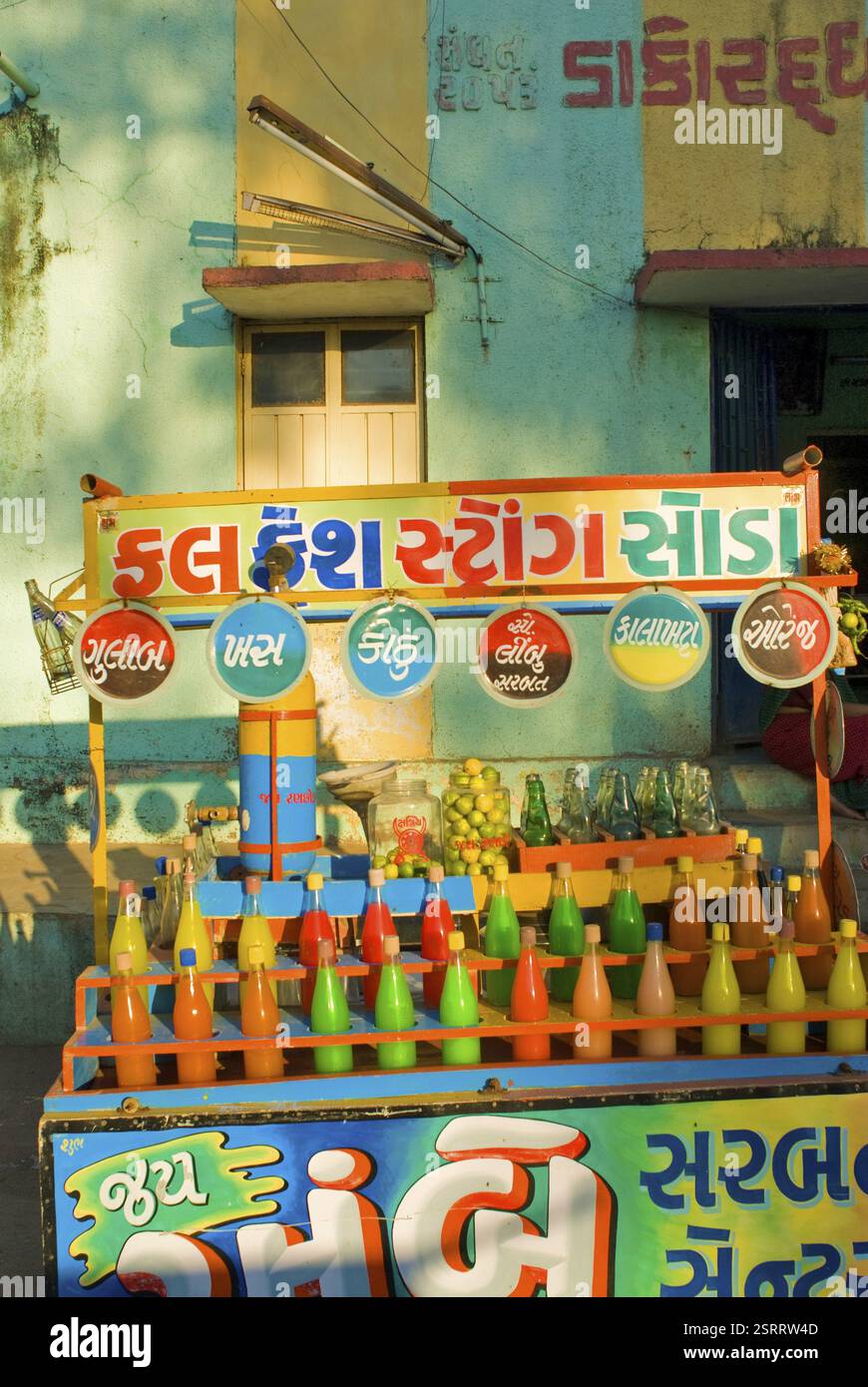 Glass bottles filled with flavoured syrups at roadside cold drink stall ...