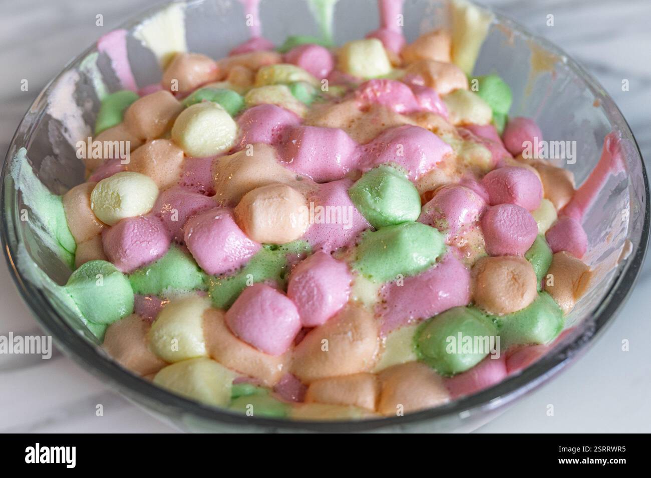 A delicious mix of pastel marshmallows melting in a glass bowl ...