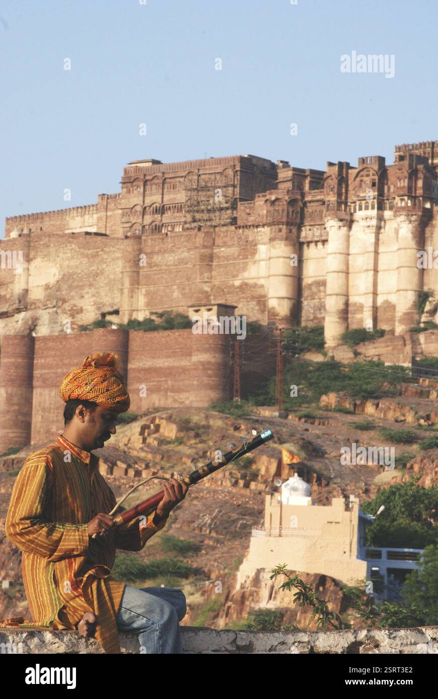 Folksinger playing ravanhatta in backdrop Mehrangarh fort, Jodhpur ...