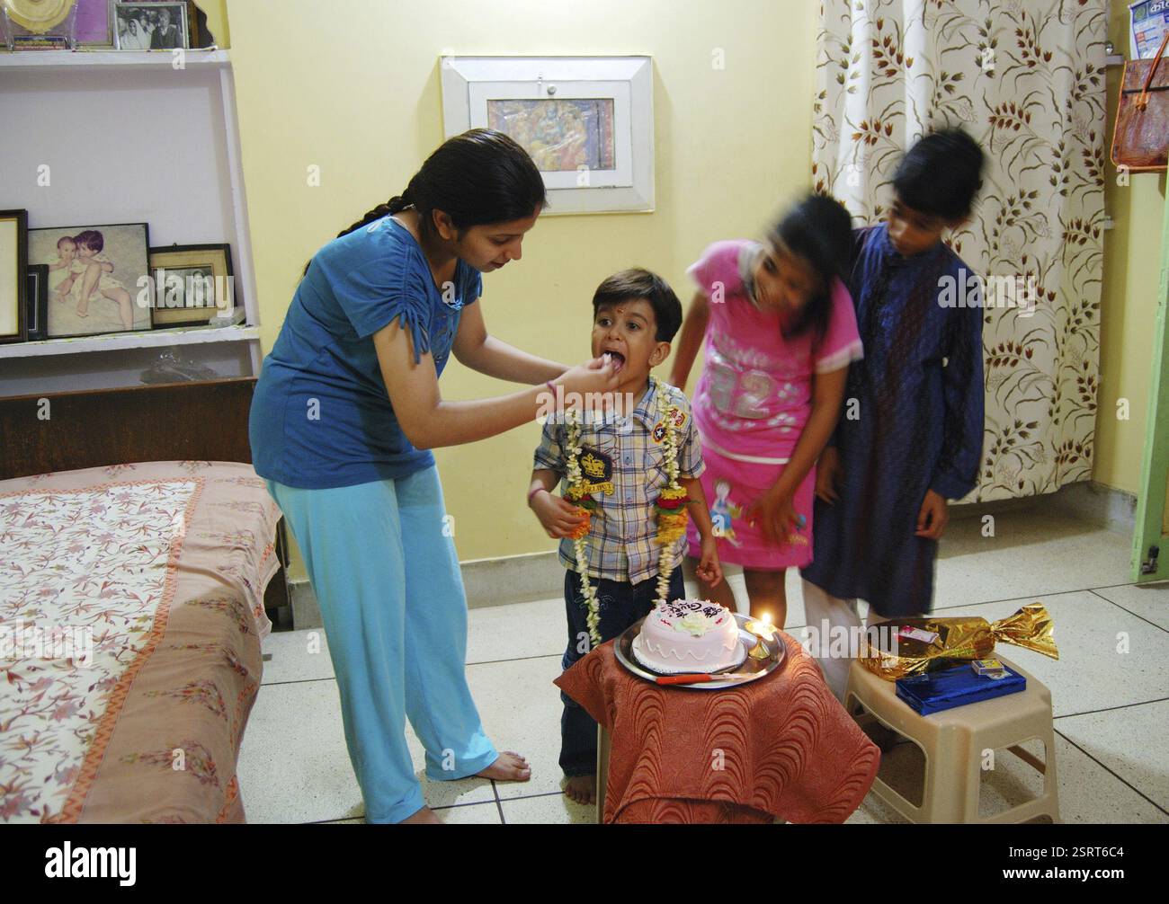Elder sister giving piece of cake to little younger brother on his ...
