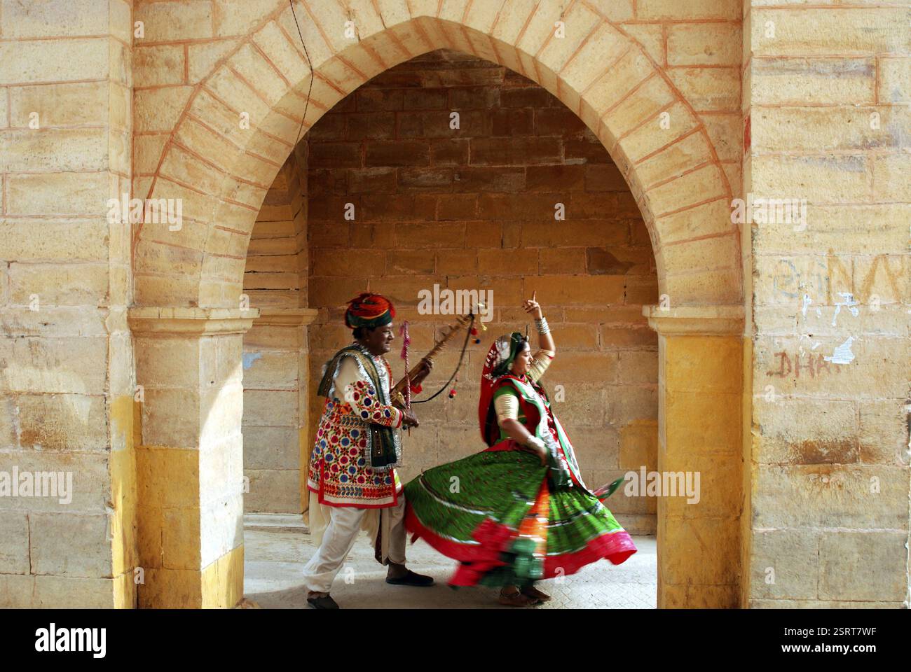 Folk dancer dancing with musician playing ravanhatta in porch of ...