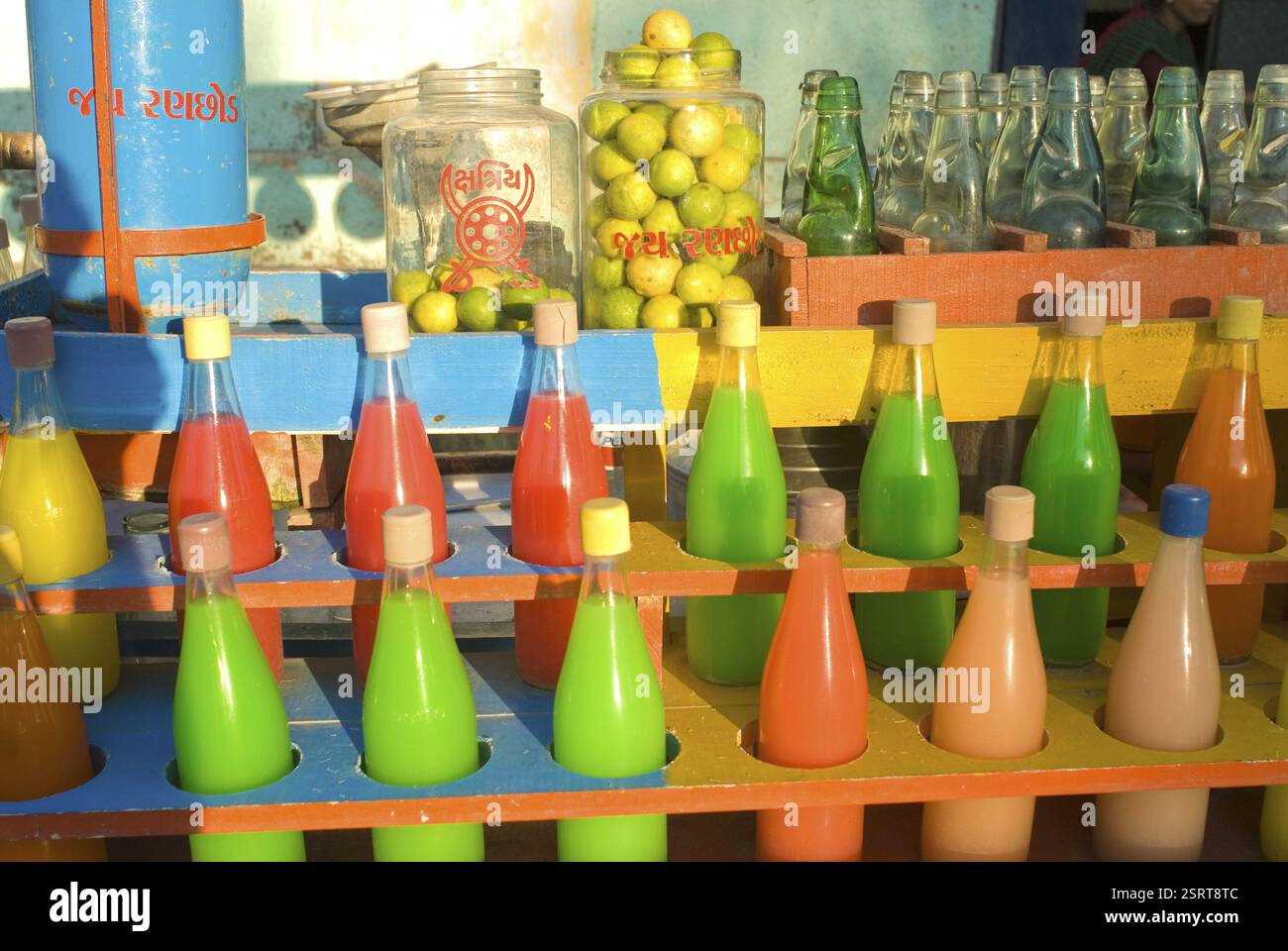 Glass bottles filled with flavoured syrups at roadside cold drink stall ...