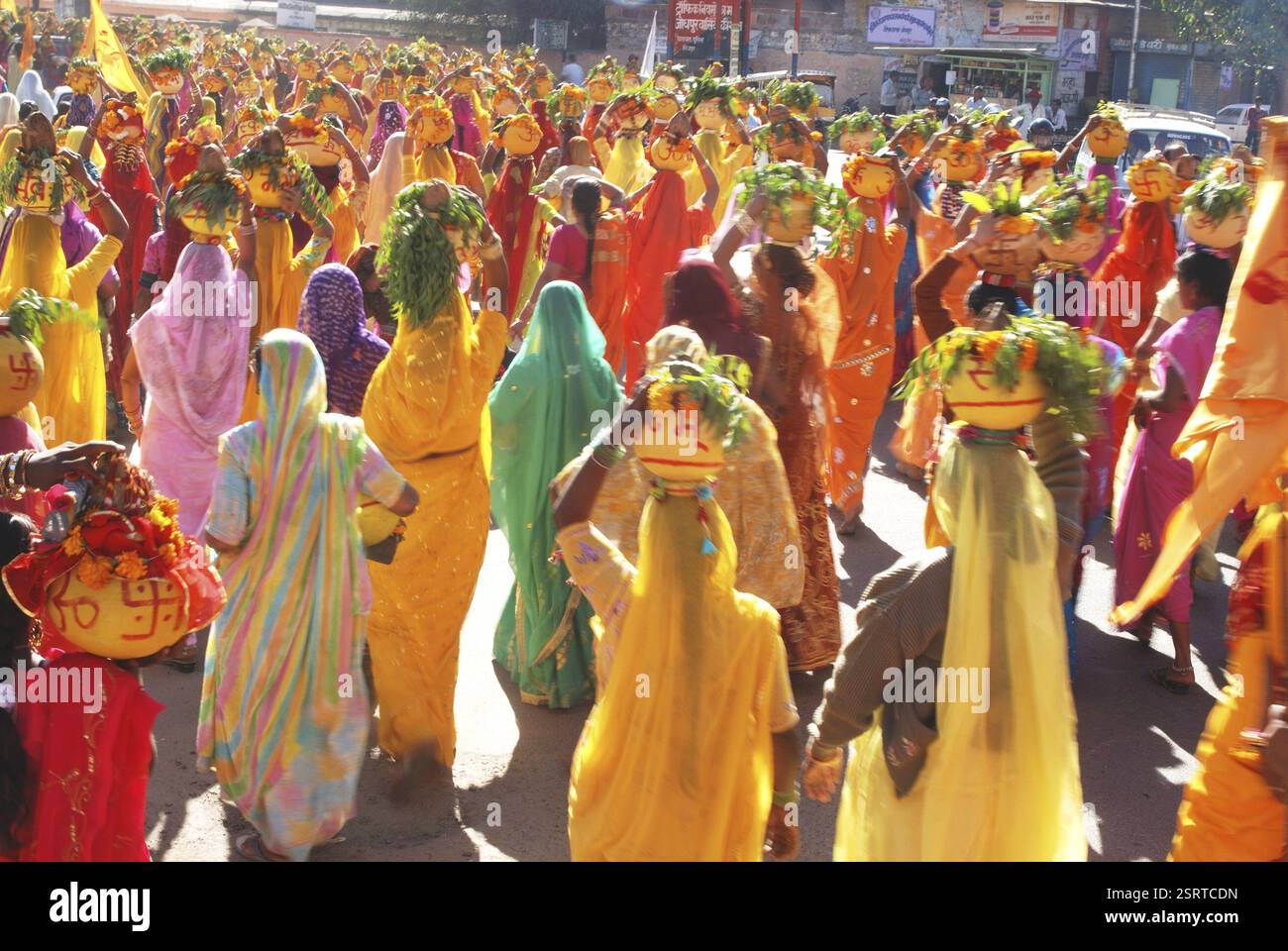 Rajasthani ladies in colourful sari and yellow pitcher on head ...