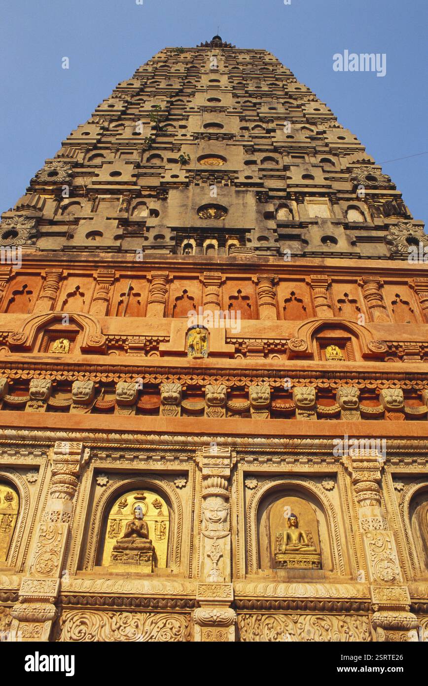 Buddha carved in different aspect on wall and soaring tower of ...