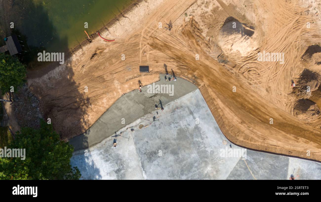 Aerial view of landscaping construction site with workers pouring ...