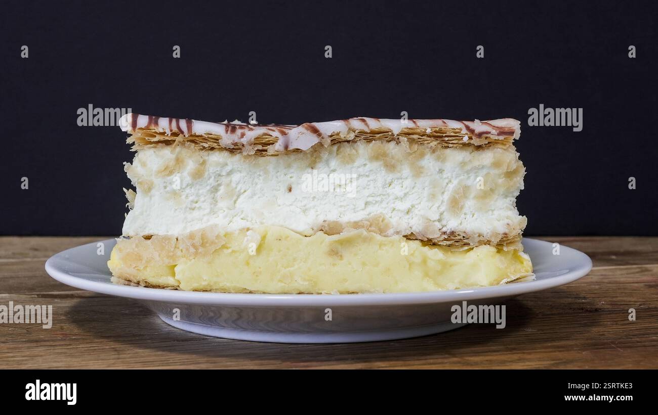 A rich layered Napoleon dessert features creamy custard, whipped cream ...