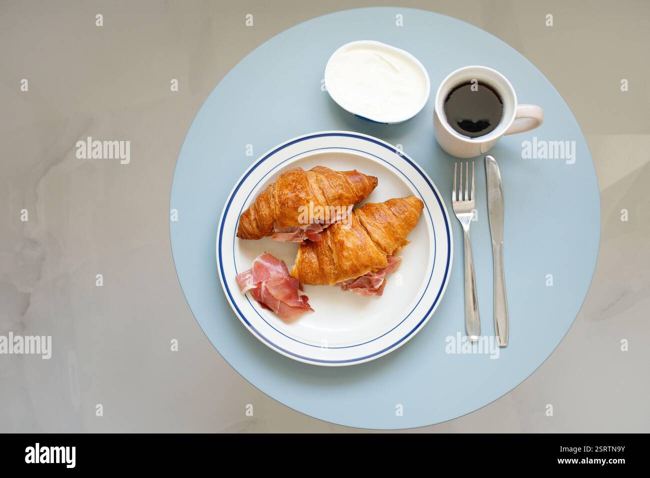 Two classic croissants with prosciutto and cream cheese with black ...