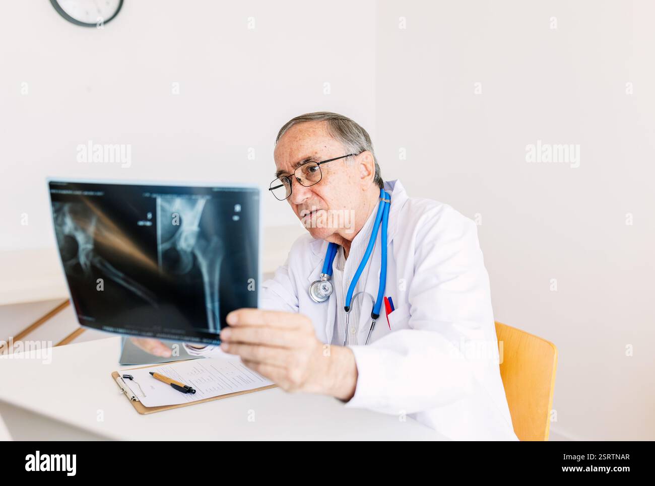 Senior doctor examining x-ray of pelvic bone in medical office Stock ...