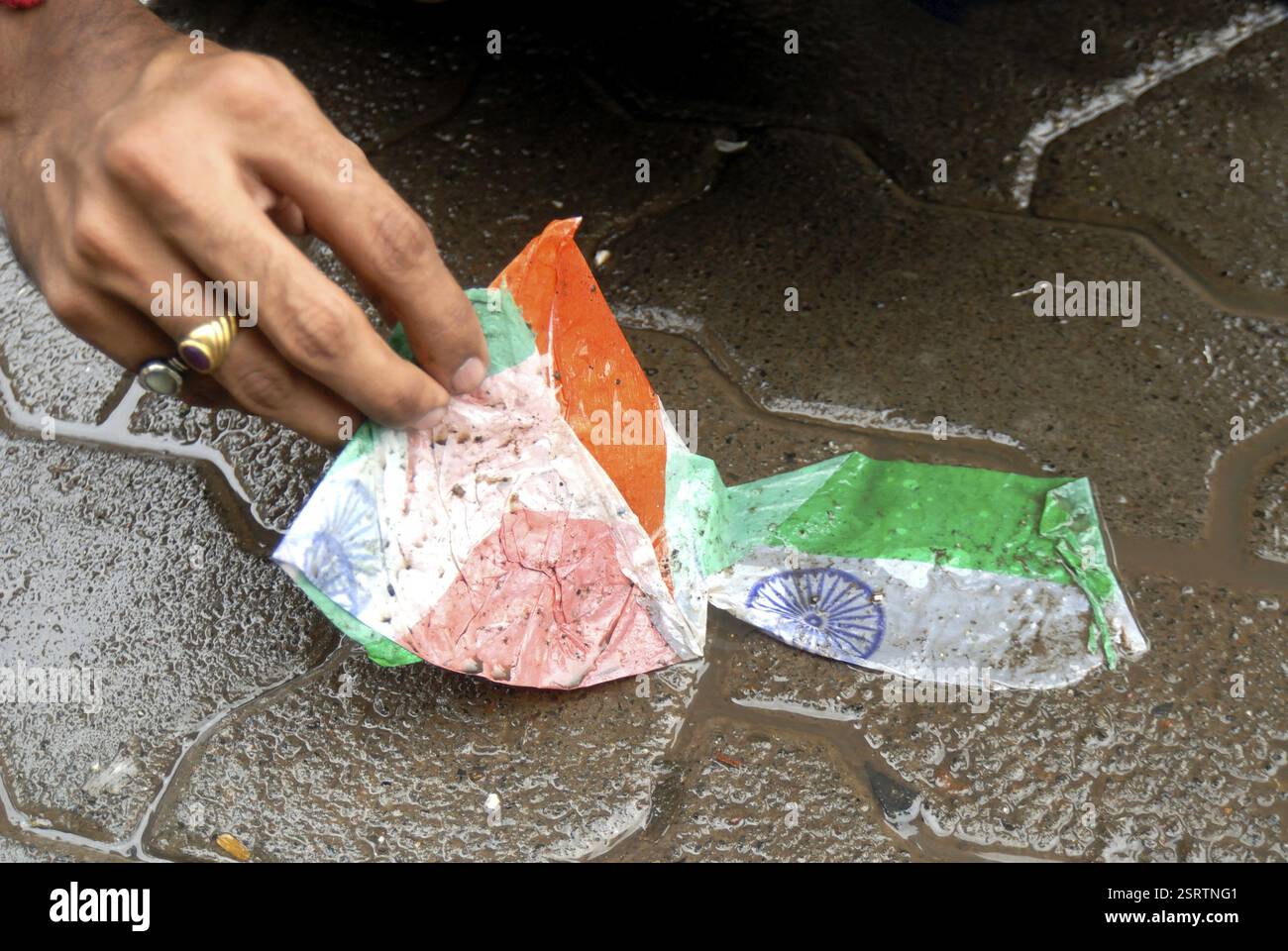 Hand collecting plastic Indian tri color flag thrown on road in Bombay ...