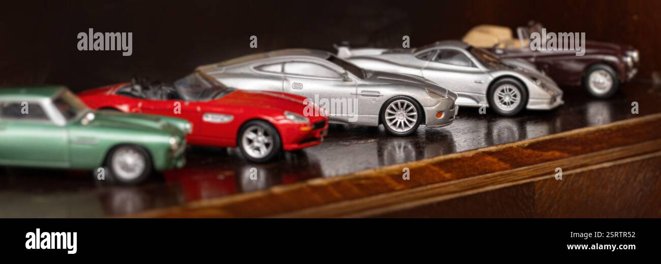 Toy cars are lined up on a wooden shelf, creating a miniature car show ...
