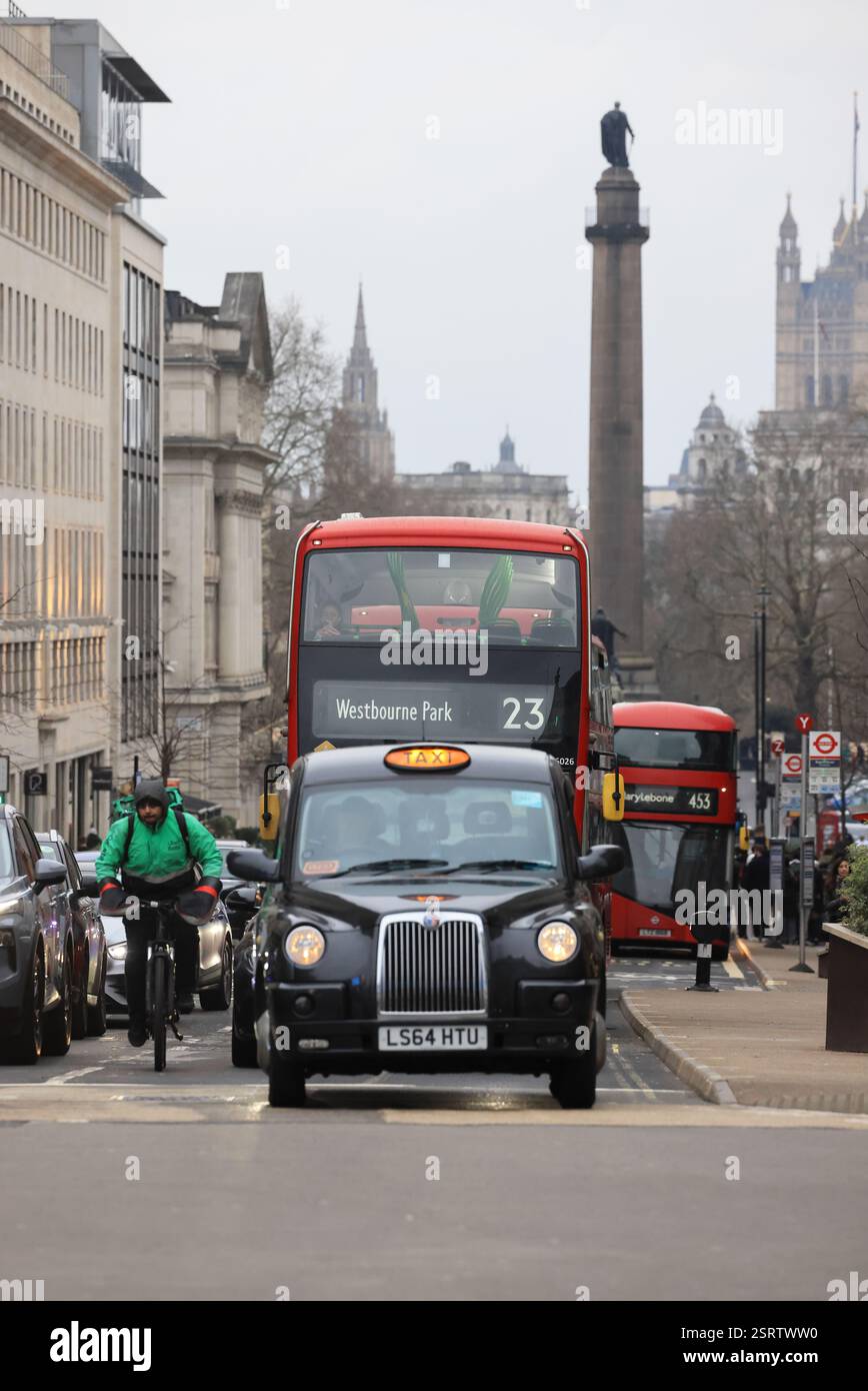 Traffic including double decker buses and black cabs and cyclists on ...
