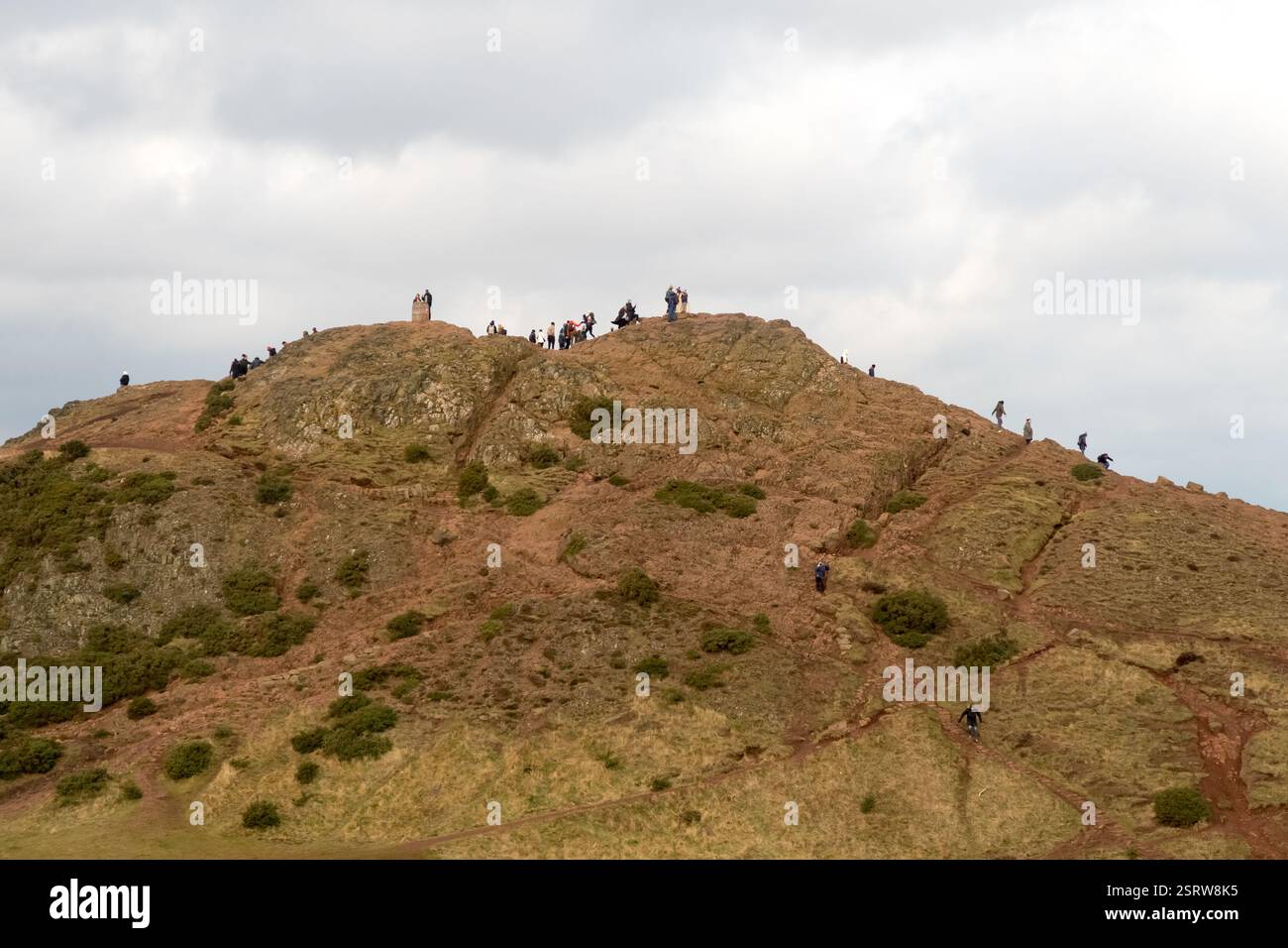 A crowded summit at Arthur’s Seat, where hikers and tourists gather to ...