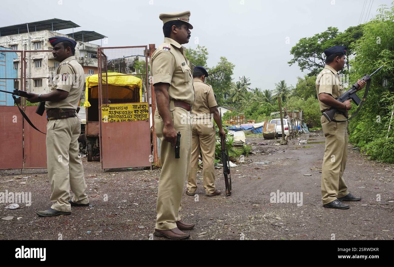 Armed policemen conduct a search and combing operation in a slum area ...