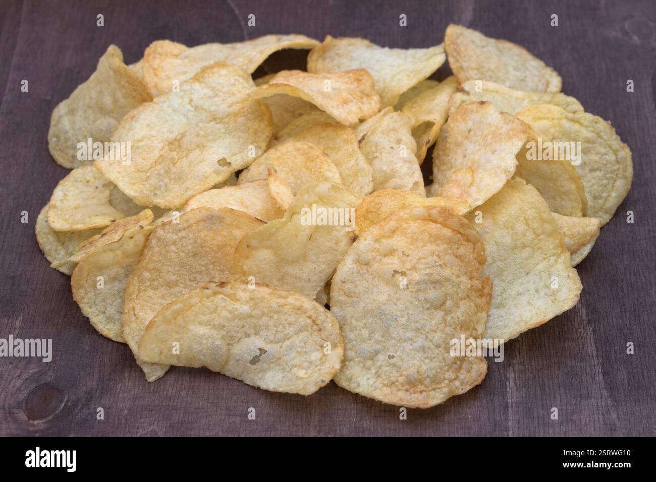 Potato chips, stack on wood floor Stock Photo - Alamy