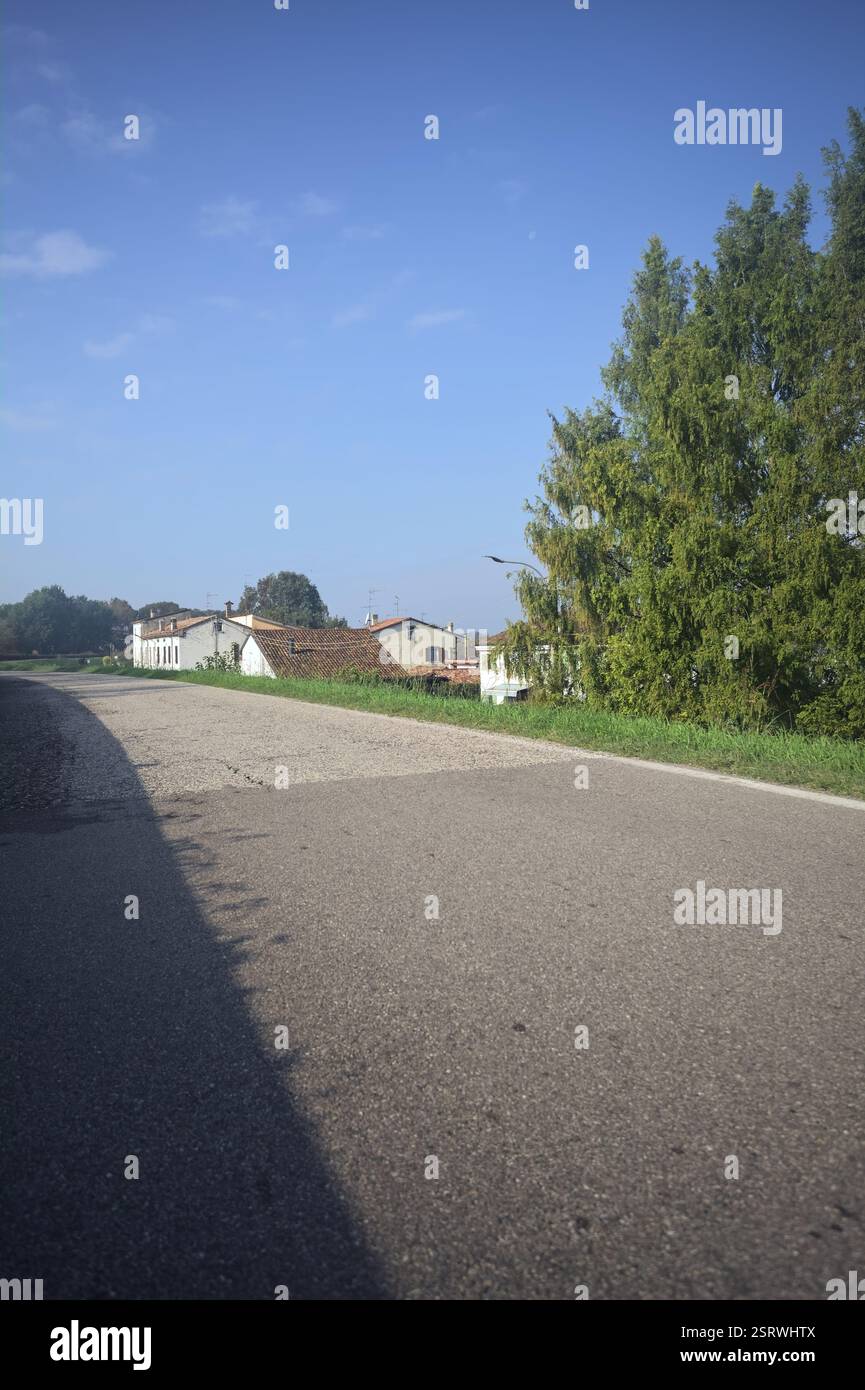Country road over an embankment passing next to a village and a park on ...