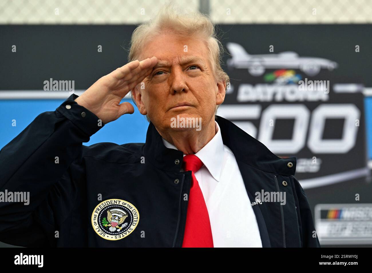 President Donald Trump salutes as he attends the NASCAR Daytona 500 ...