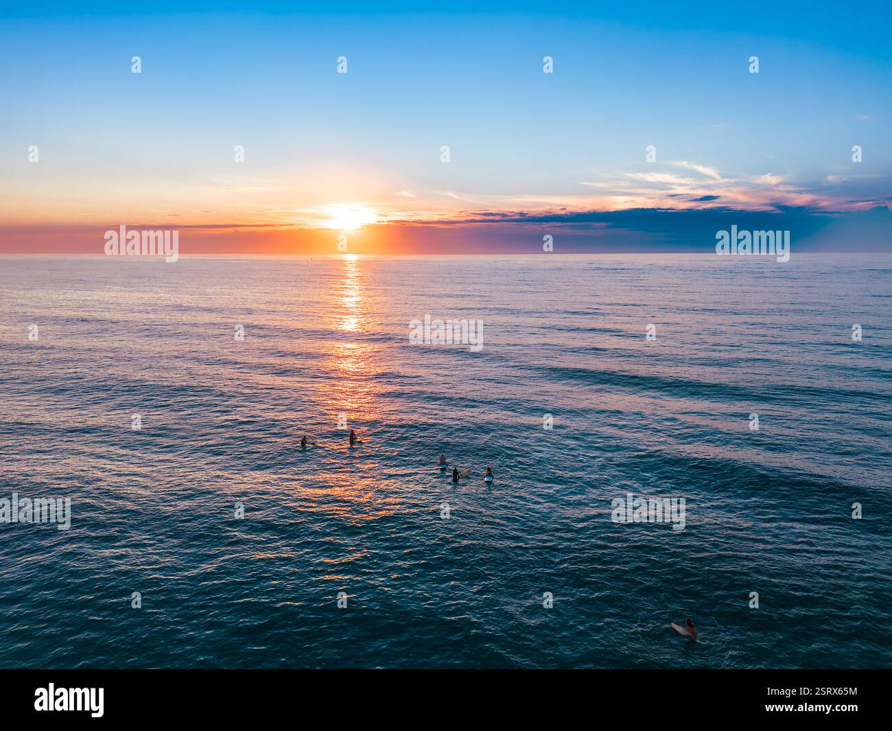 A drone view of the sun rising over the horizon as it reflects on the ...