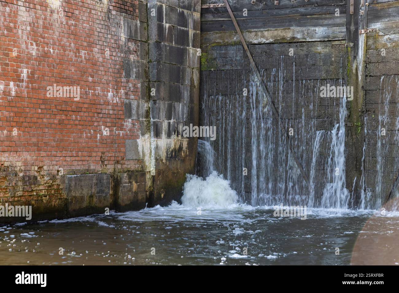 a leaking old wooden dam with a lot of holes, old wooden fences with ...