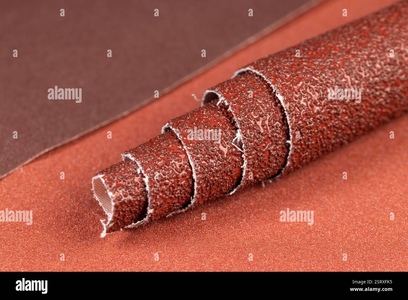 coarse-grained sandpaper for working with wood and metal rolled into a ...